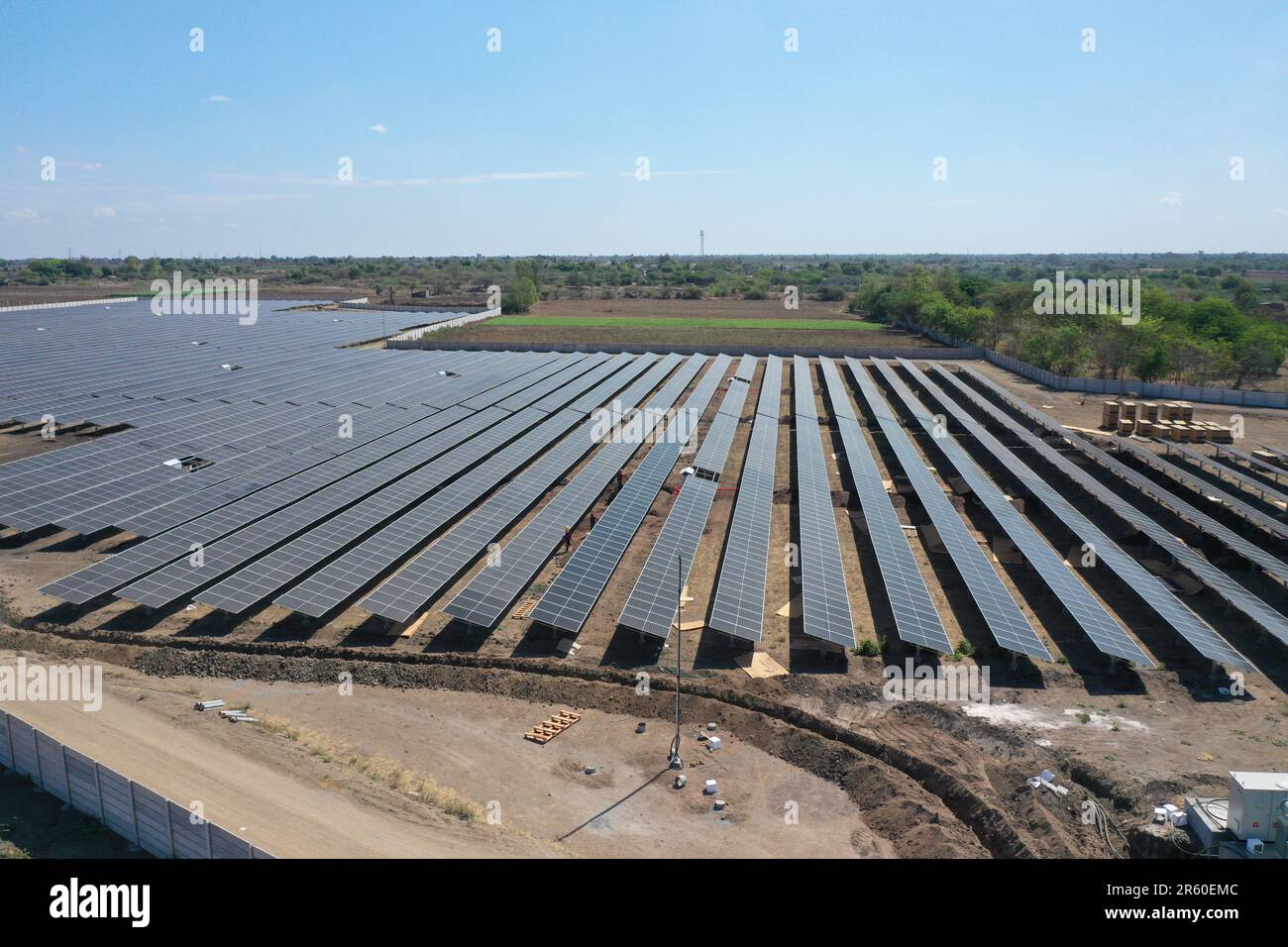 An aerial view of a large-scale solar farm with an array of black solar ...