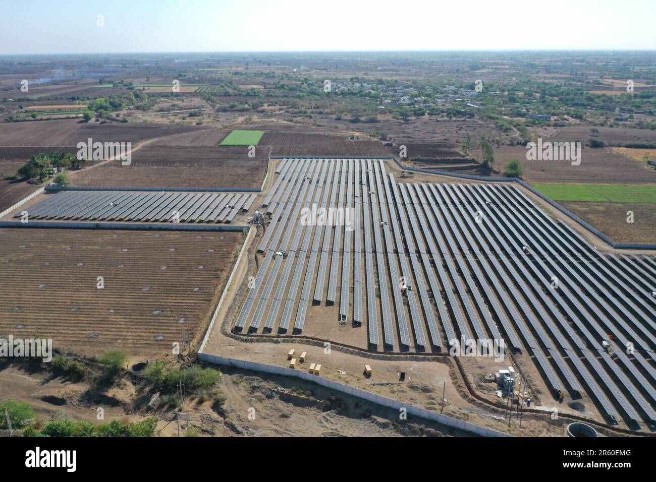 An aerial view of a large-scale solar farm with an array of black solar ...