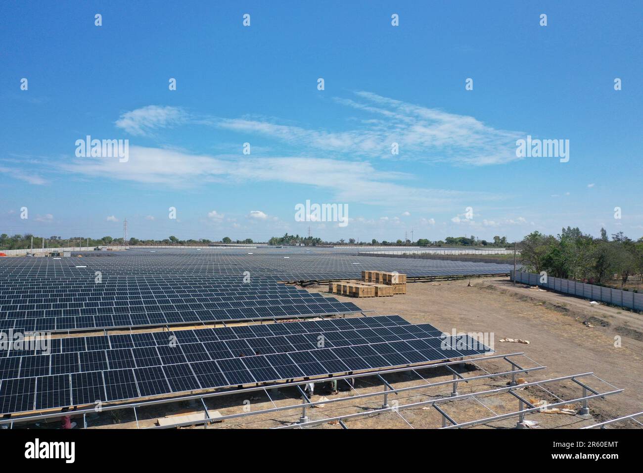 An aerial view of a large-scale solar farm with an array of black solar ...
