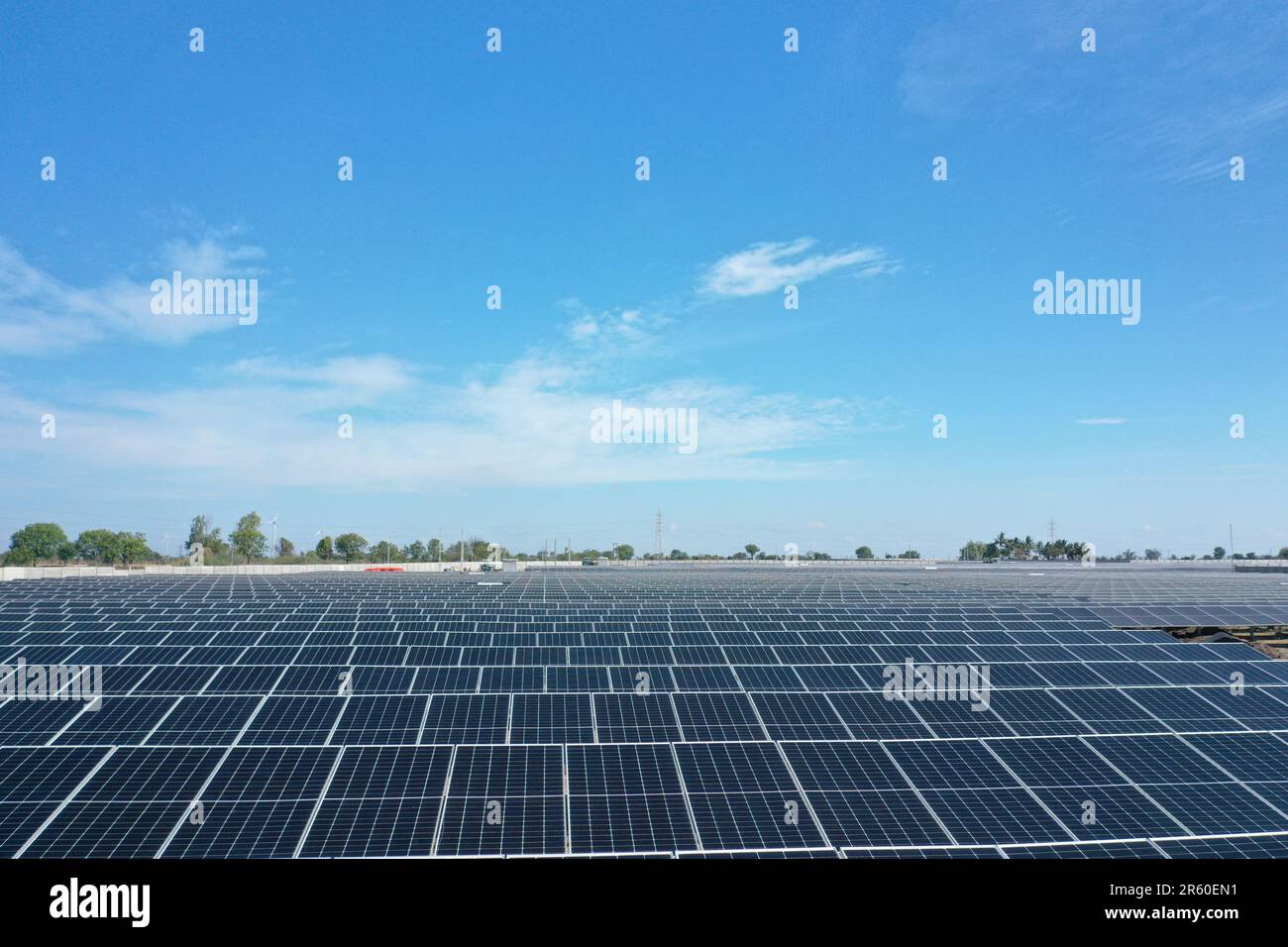 An aerial view of a large-scale solar farm with an array of black solar ...