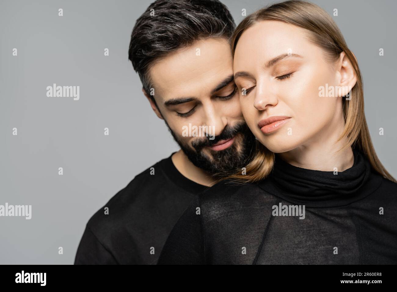 Portrait of relaxed and bearded man in black t-shirt standing next to ...