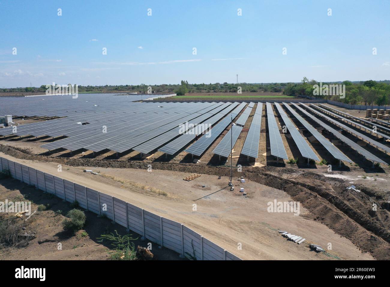 An aerial view of a large-scale solar farm with an array of black solar ...