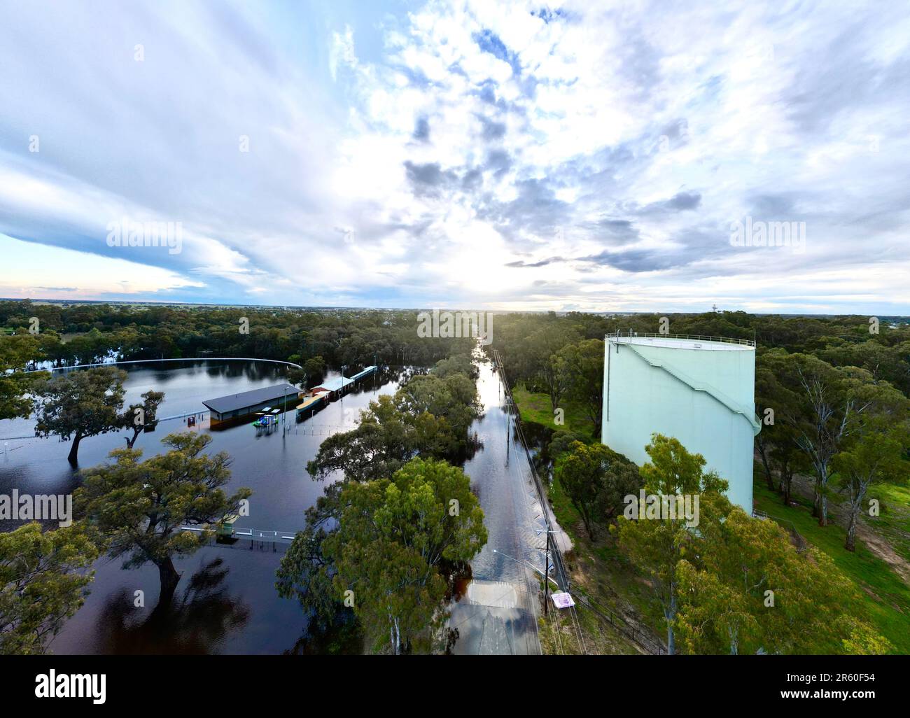 A tranquil body of water lies beneath a cloudless, sunny sky, its ...