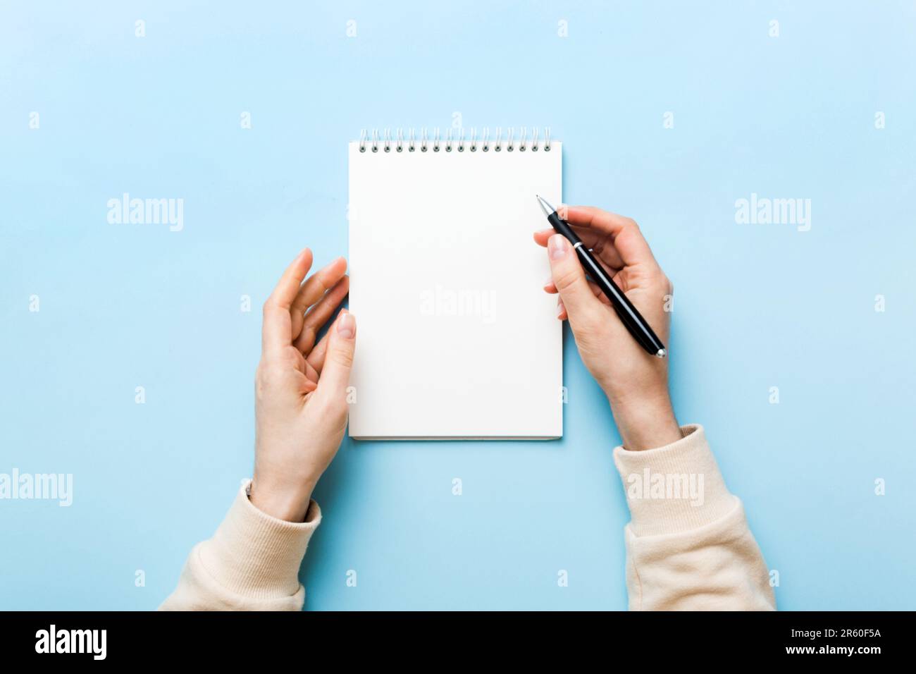 Woman hand with pencil writing on notebook. Woman working on office ...