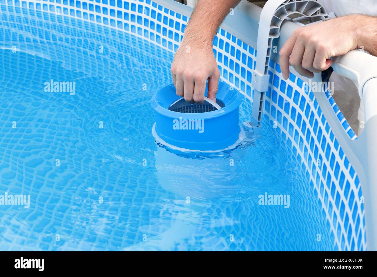 Man cleans skimmer for the frame pool. Contaminated pool cleaning ...