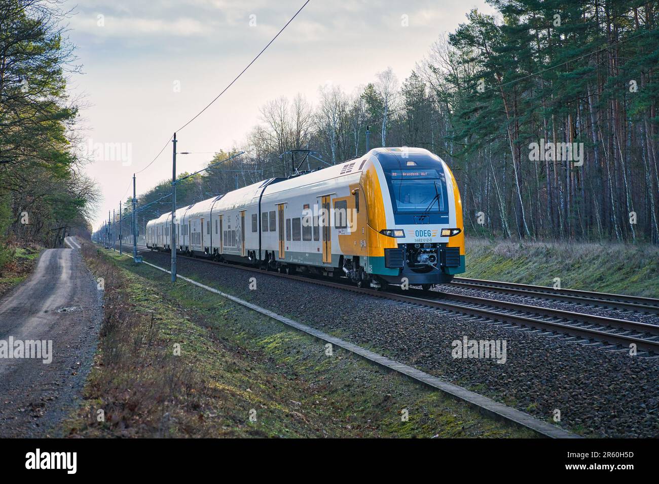A vintage train moves along the tracks in a landscape, with lush green ...