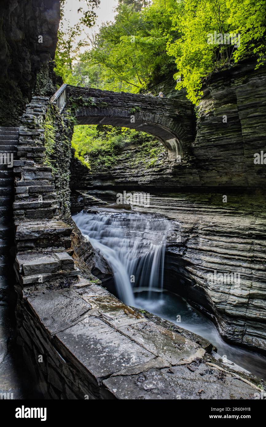 A waterfall cascading down over rocks in forest setting Stock Photo - Alamy