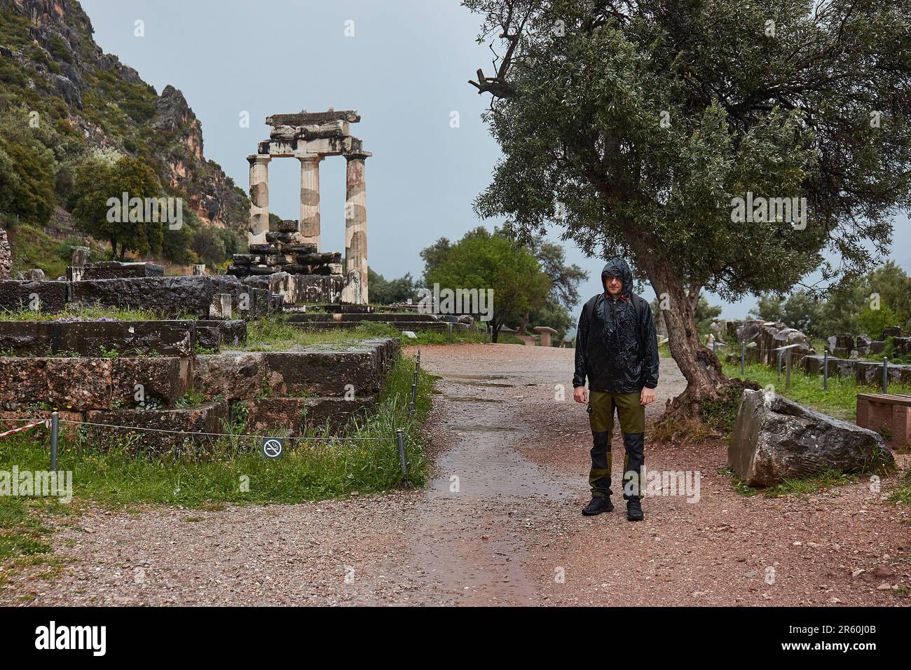 Ancient greek ruins in Delphi, tourist in the rain Stock Photo - Alamy