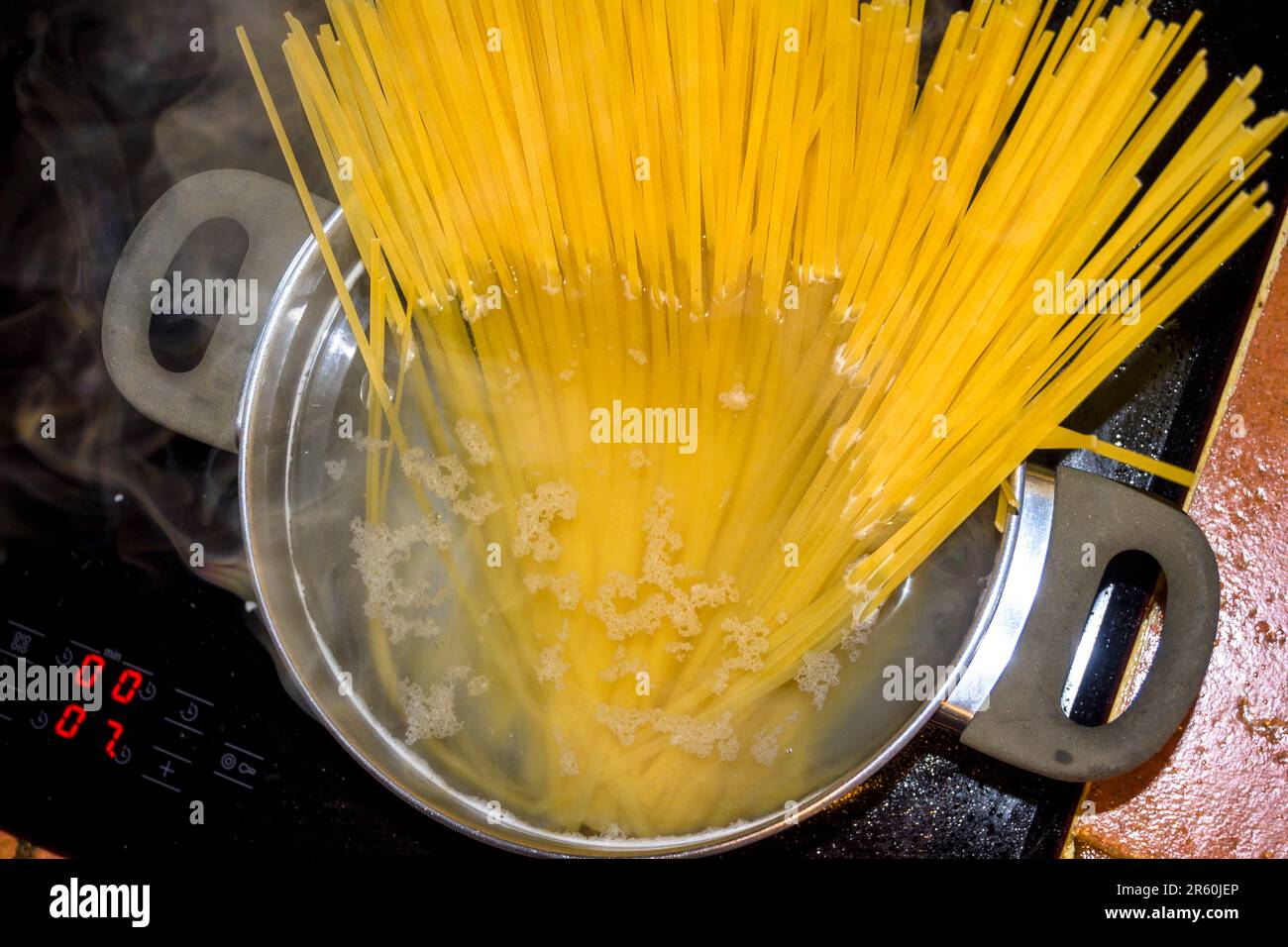 Spaghetti noodles cooking in casserole on ceramic hob with steam horizontal Stock Photo - Alamy