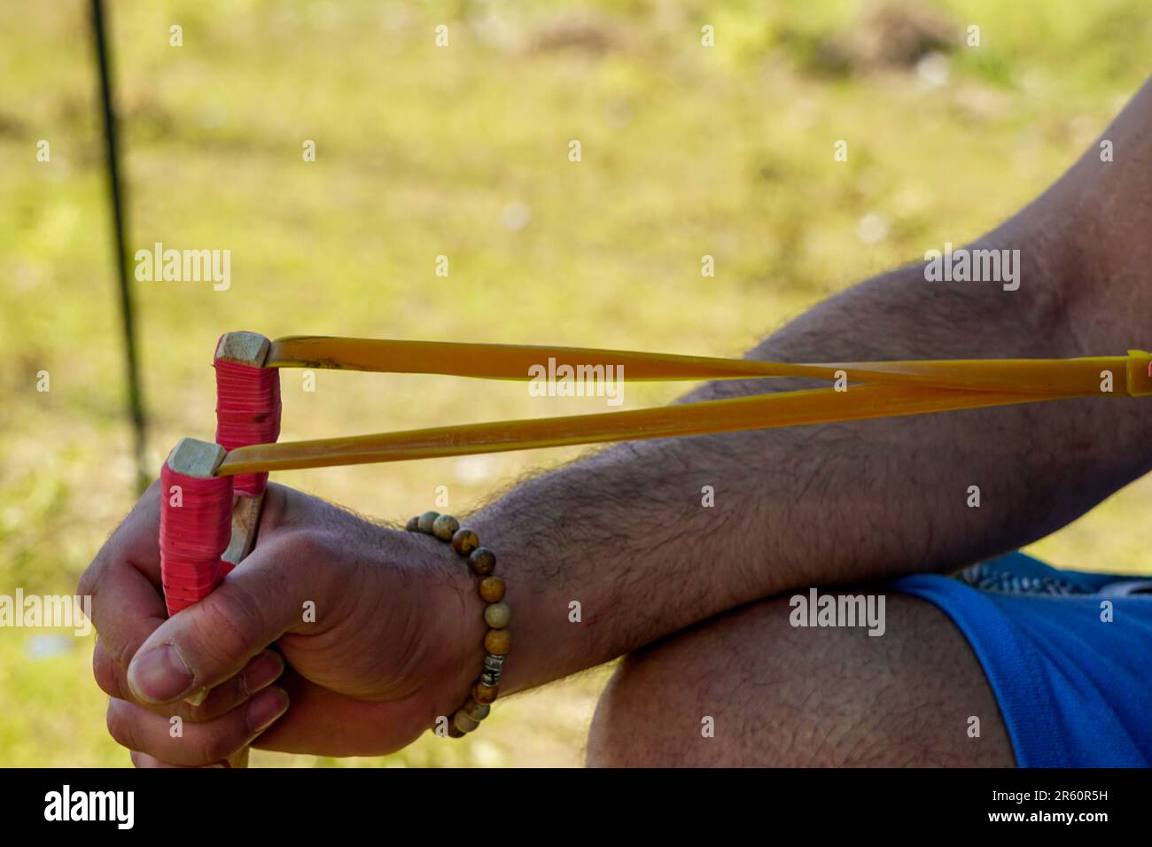 Man using spear thrower throwing rock nature amusement Stock Photo - Alamy