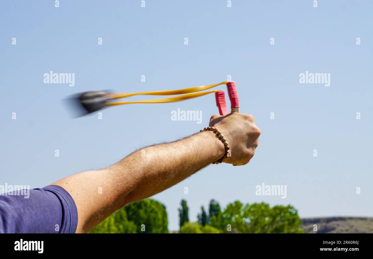 Man using spear thrower throwing rock nature amusement Stock Photo - Alamy