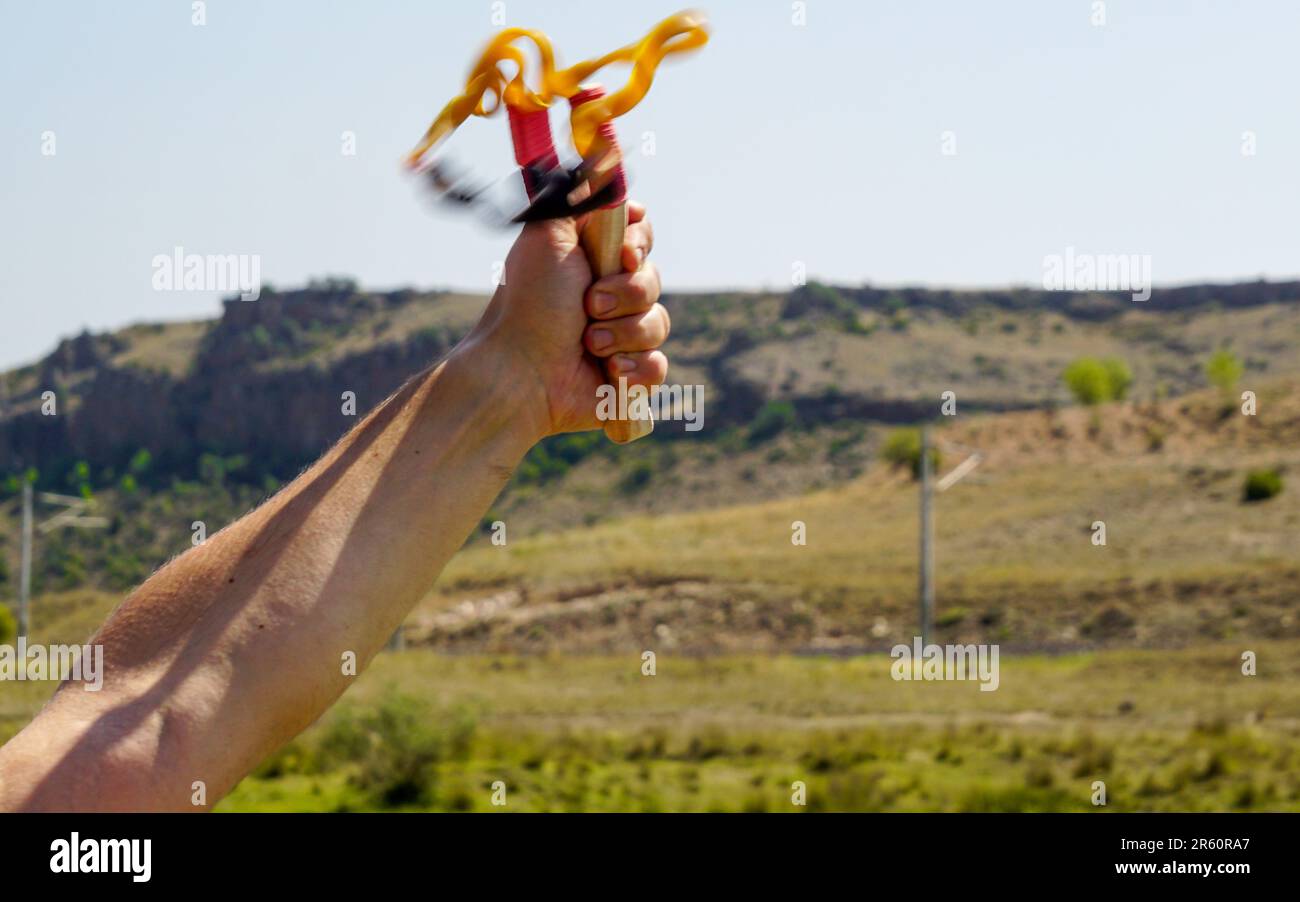 Man using spear thrower throwing rock nature amusement Stock Photo - Alamy