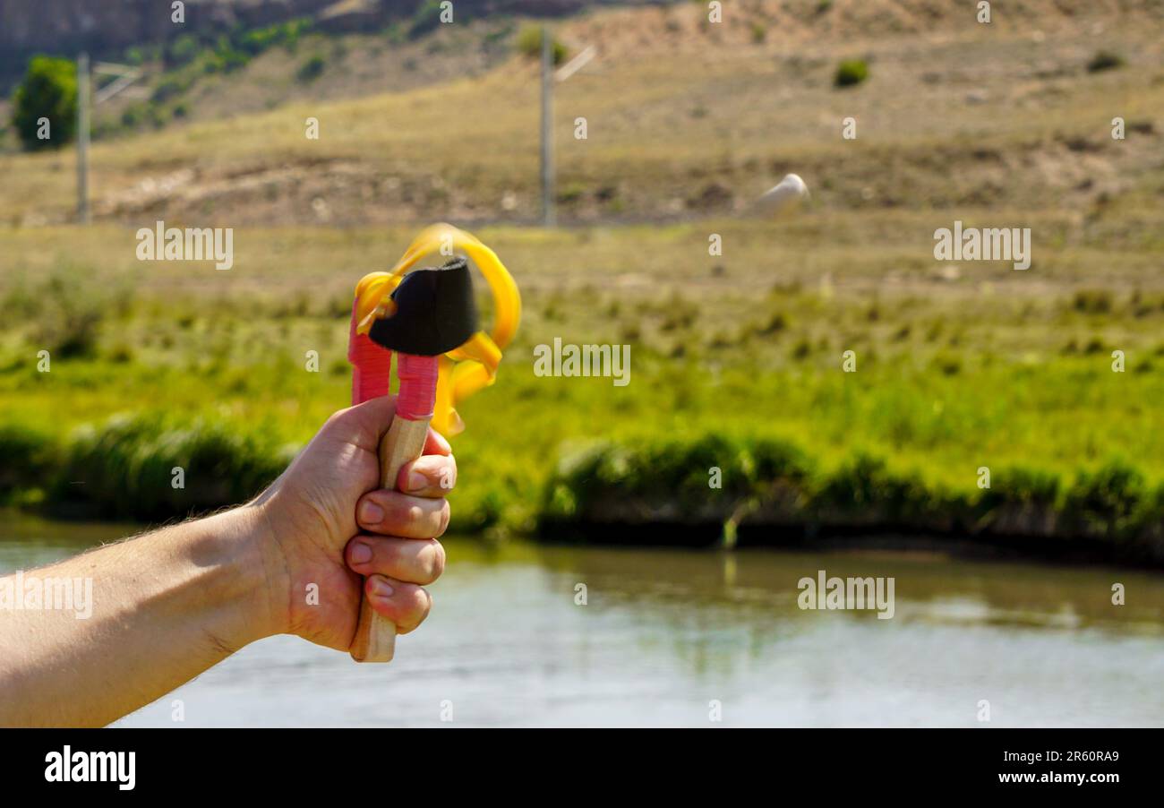 Man using spear thrower throwing rock nature amusement Stock Photo - Alamy