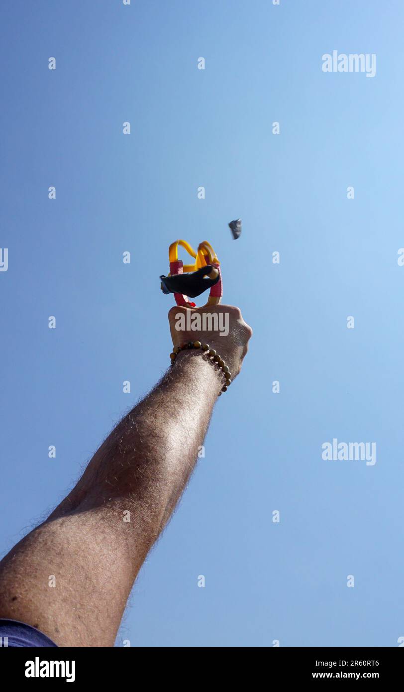 Man using spear thrower throwing rock nature amusement Stock Photo - Alamy
