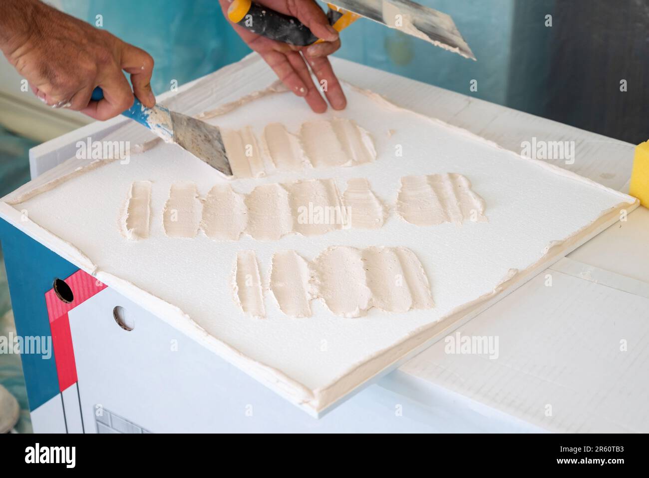 adhesive plaster application of styrofoam ceiling tiles of a home ...
