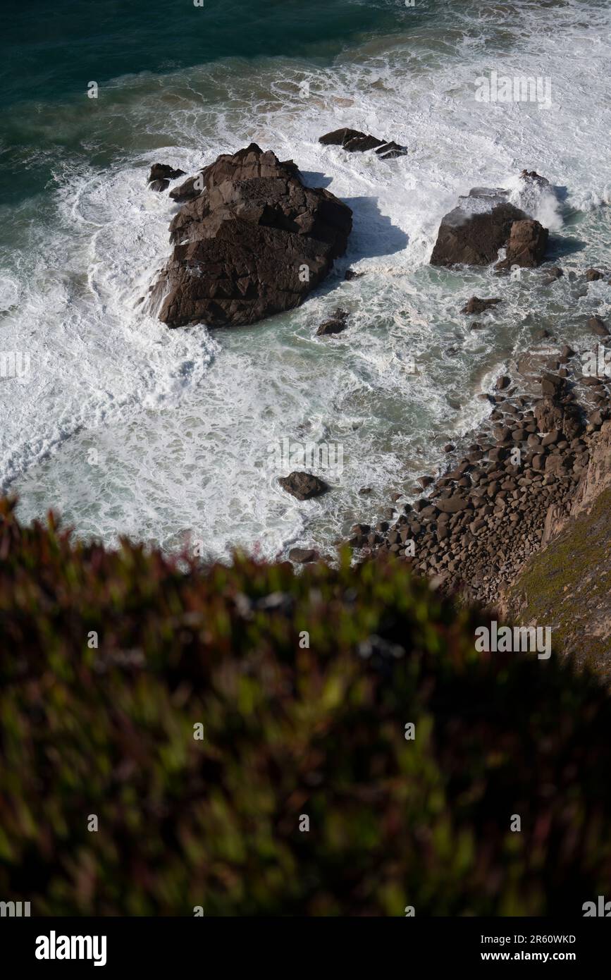 A large body of water surrounded by rocky terrain and lush vegetation ...