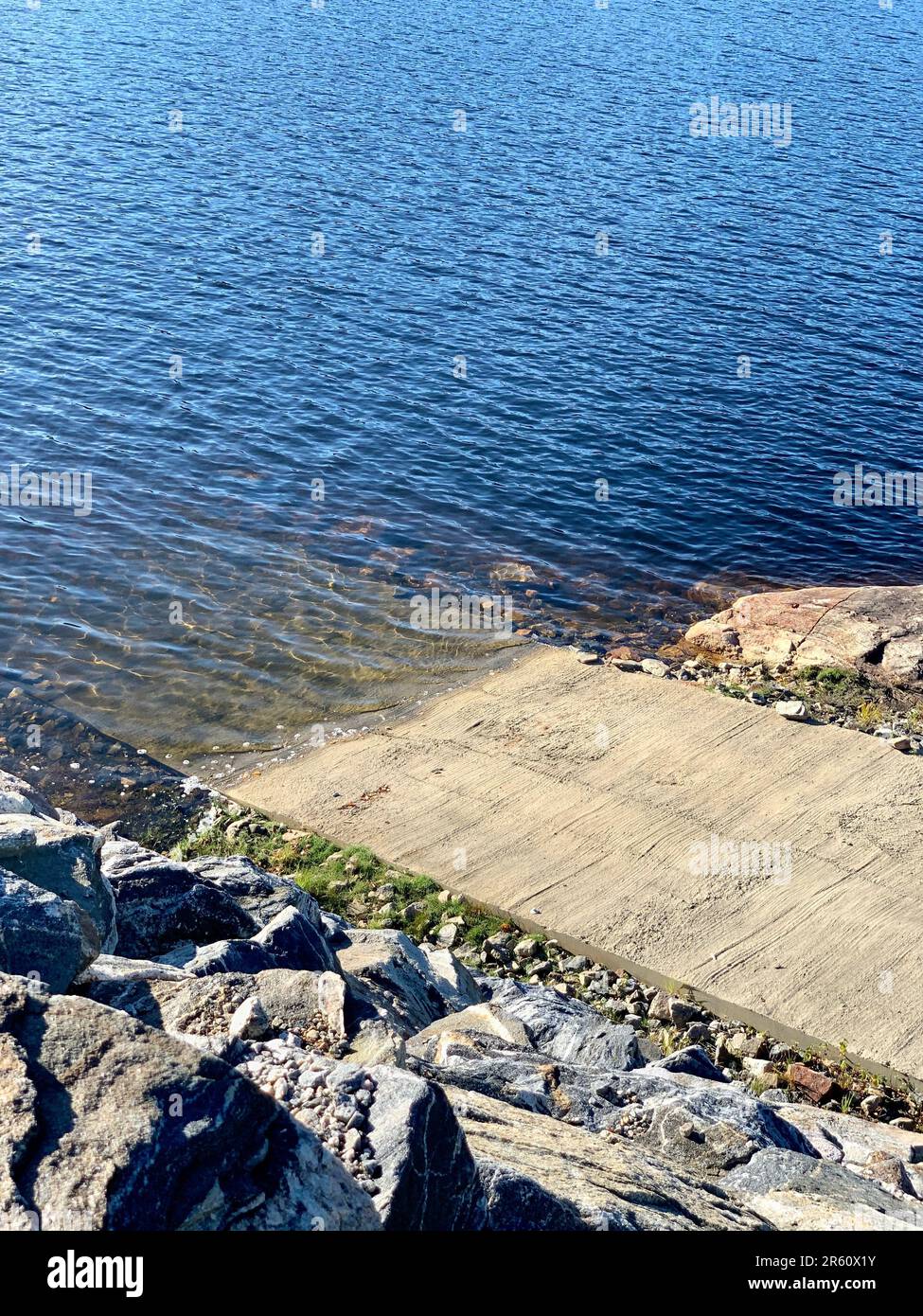 A winding stone pathway leads to a beachfront, with a serene body of ...
