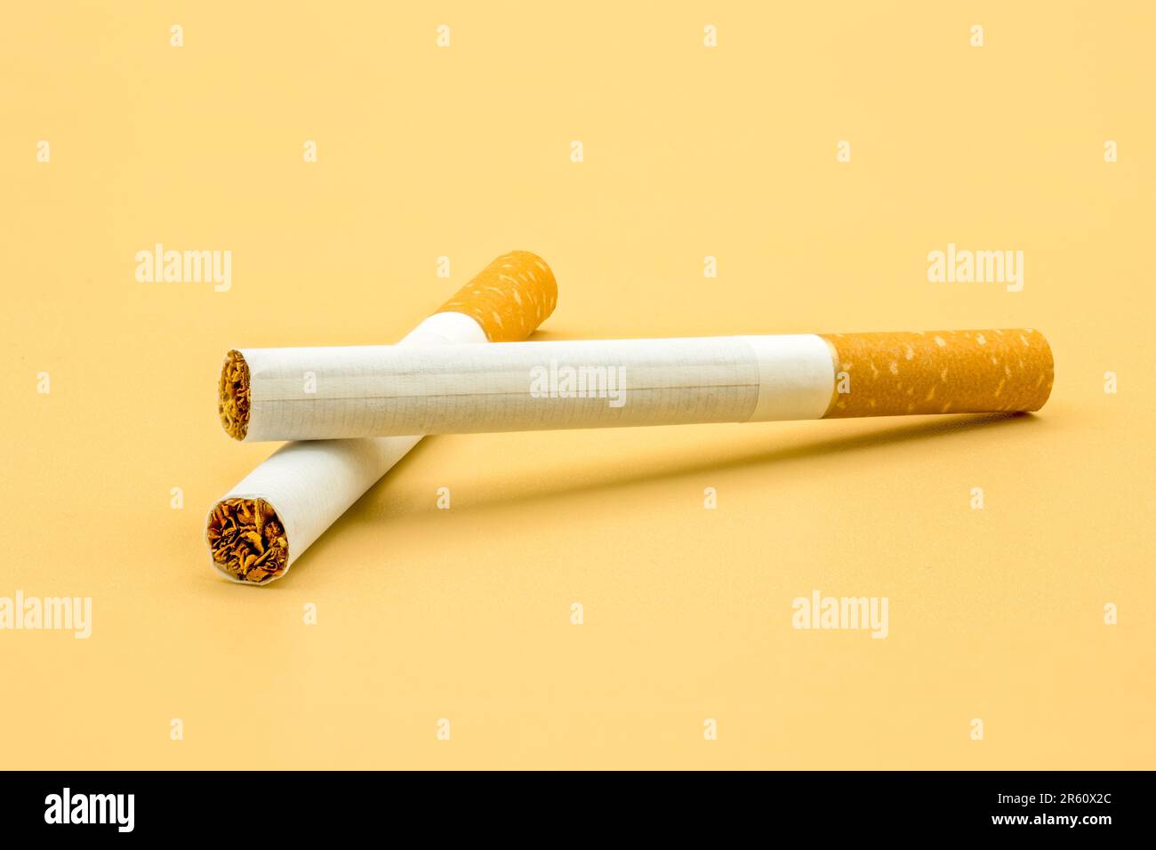 Two cigarettes lying side-by-side on a vibrant yellow background Stock ...