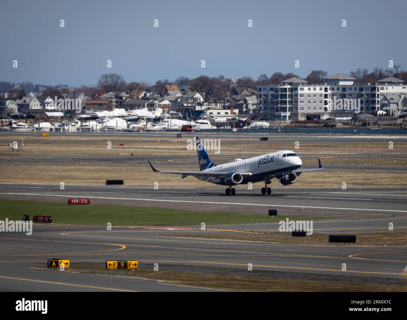 A commercial JetBlue airplane landing on a runway at an airport ...