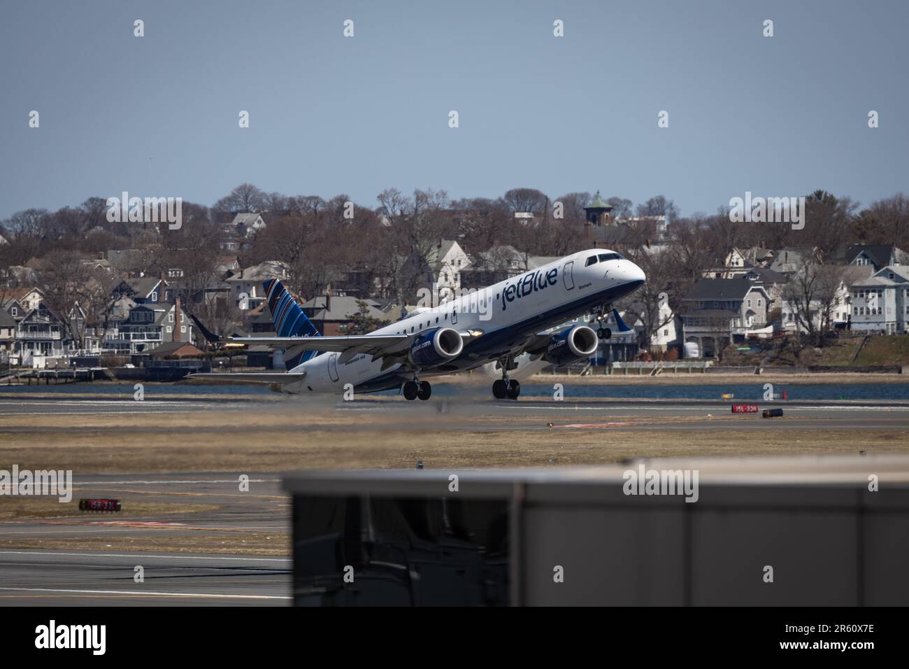 A commercial JetBlue airplane landing on a runway at an airport ...