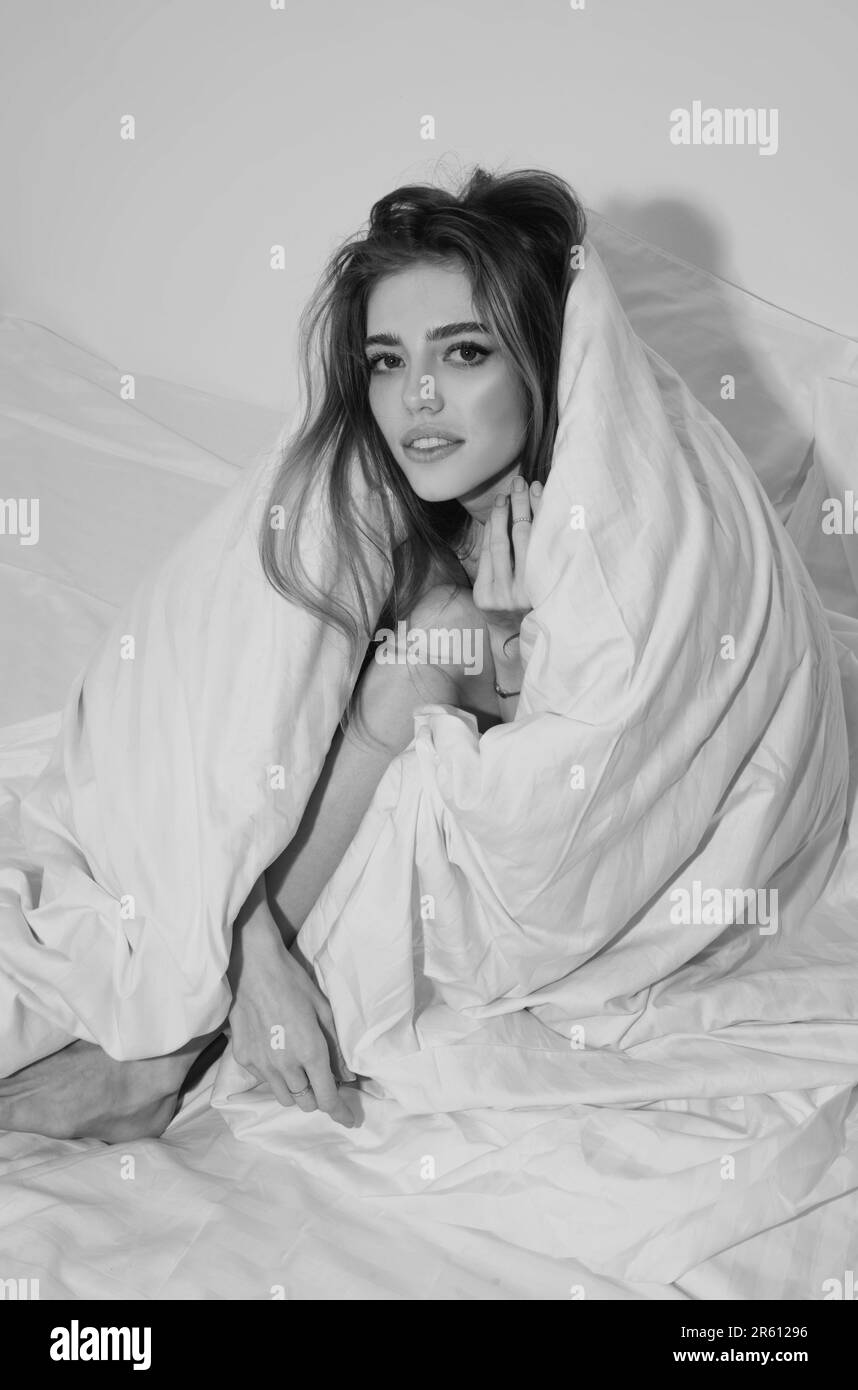 Young woman lying in bed and hiding under the sheet Stock Photo - Alamy