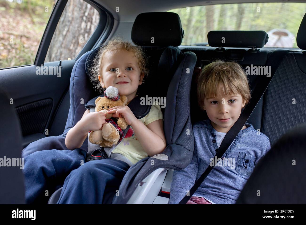 Cute children, boy and girl siblings, sitting in car seats in car ...