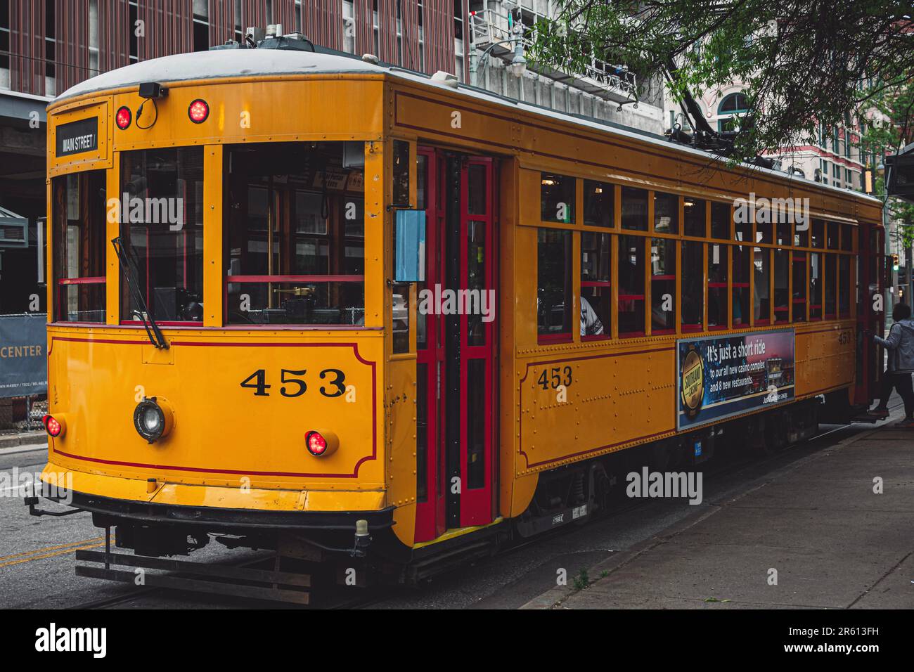A yellow trolley car with visible numbers on the front in street Stock ...