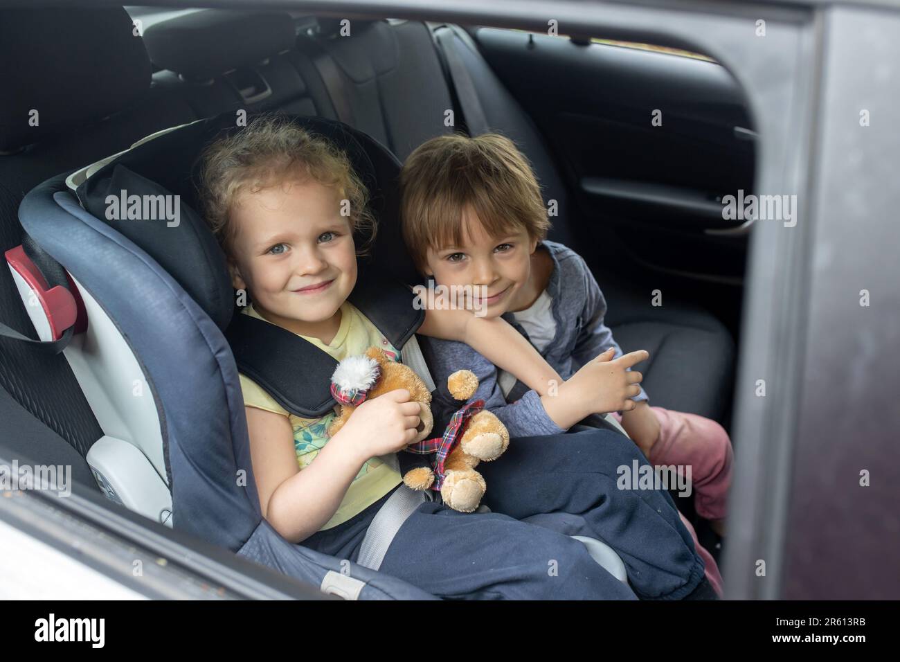Cute children, boy and girl siblings, sitting in car seats in car ...