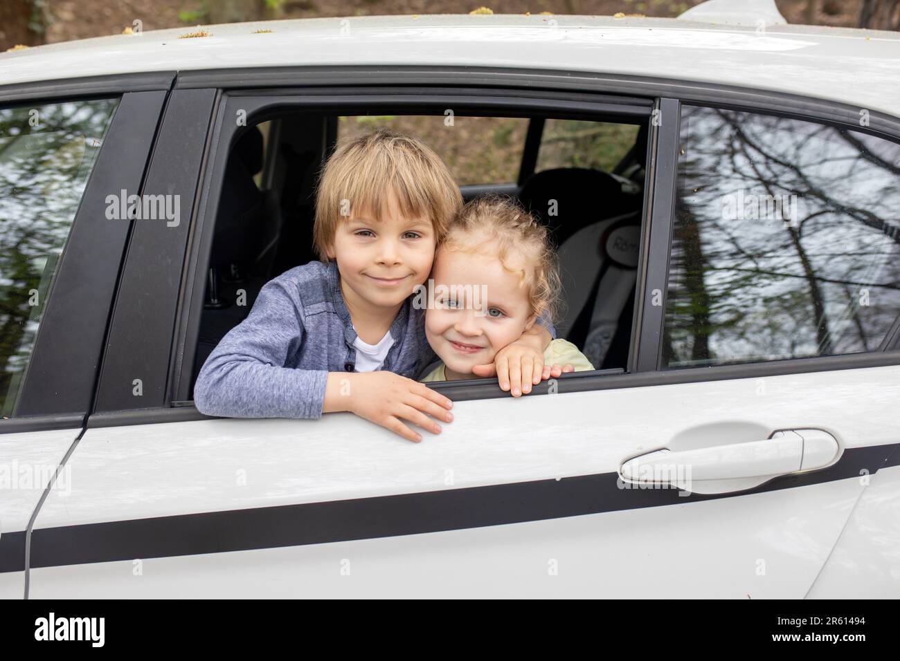 Cute children, boy and girl siblings, sitting in car seats in car ...