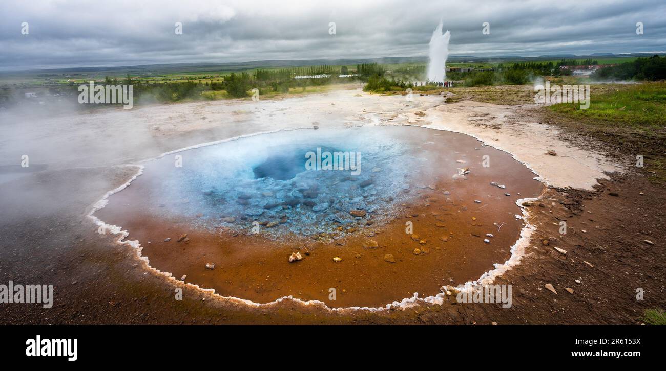An aerial view of a geyser in the middle of a sprawling landscape in ...