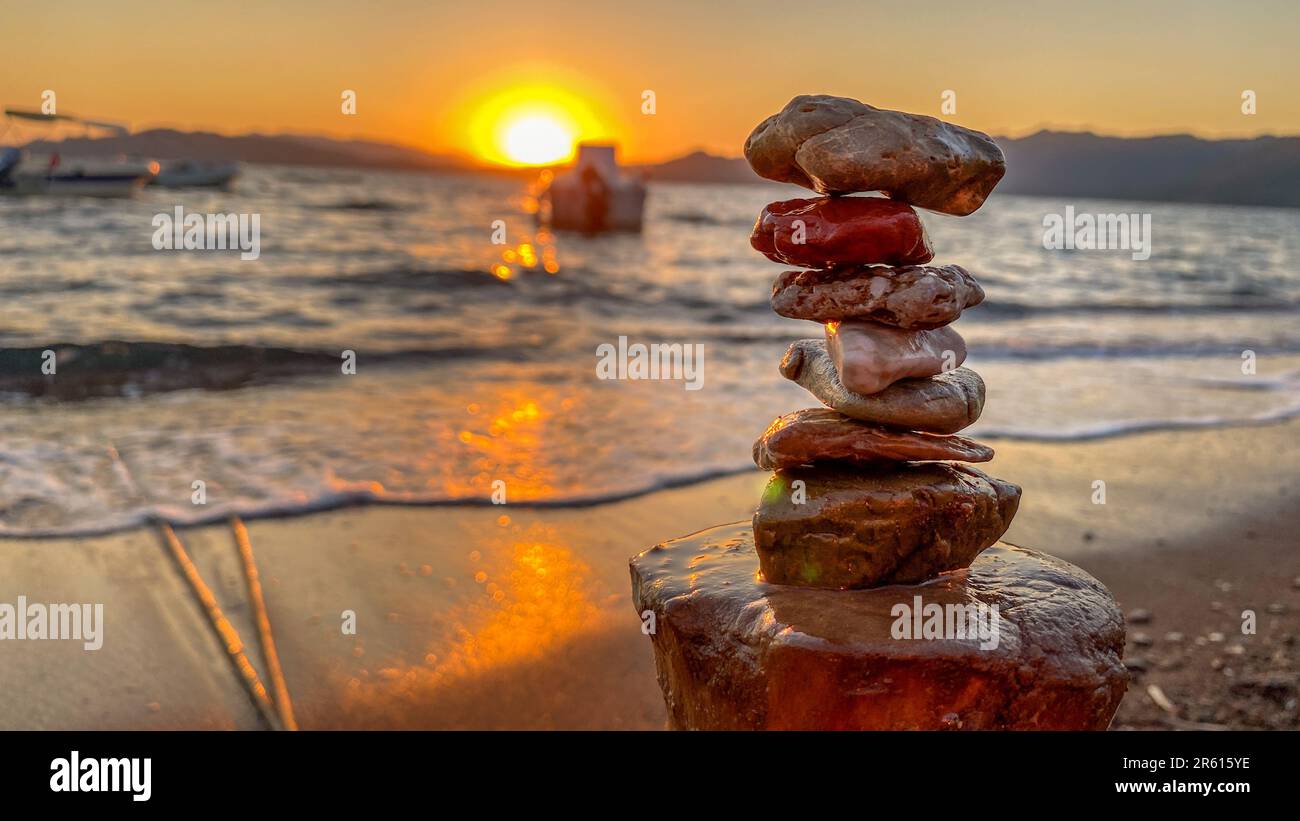 Rock balancing at the beach at sunset close up view Stock Photo - Alamy