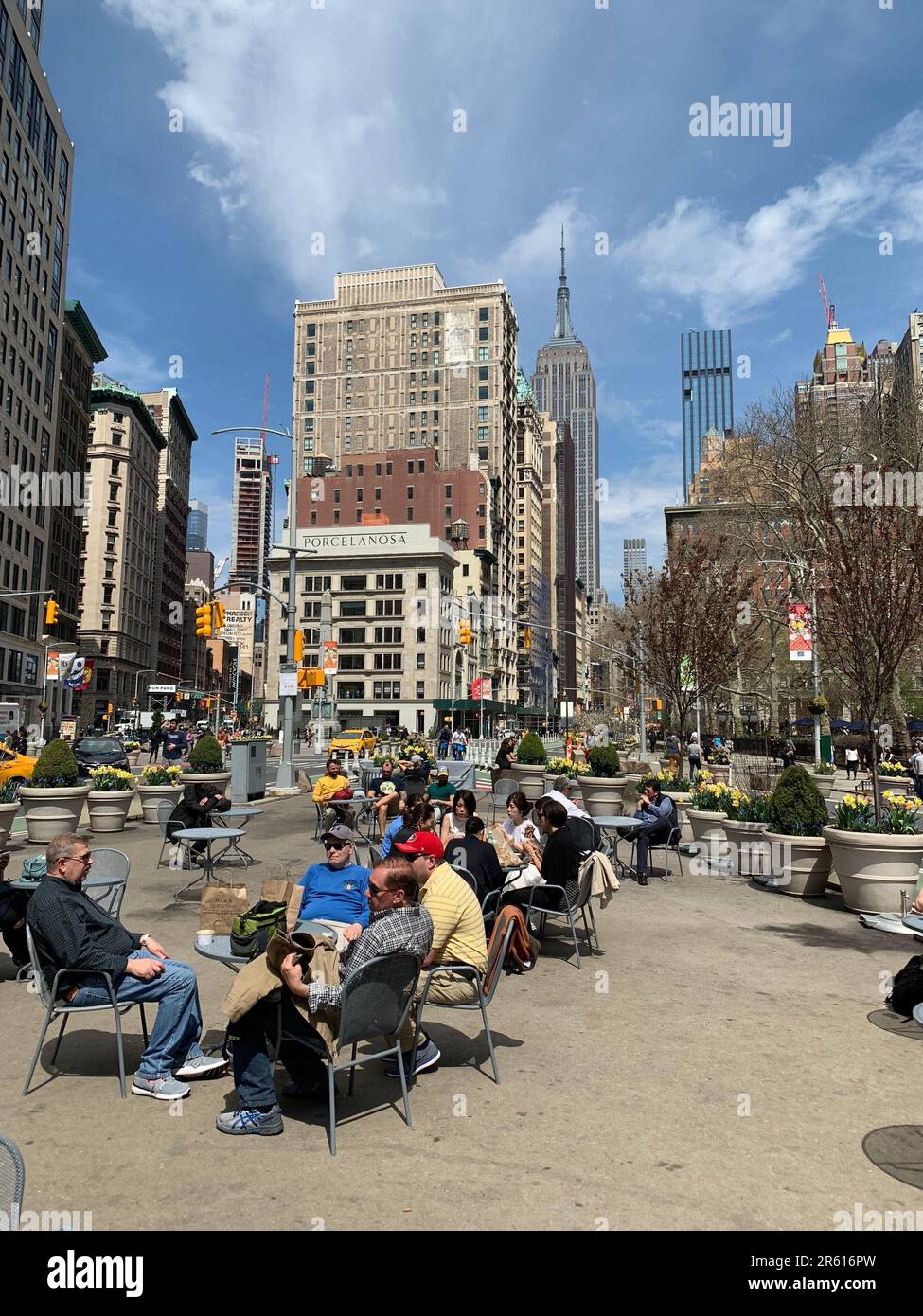 Friends enjoy an outdoor cafe in New York City on a warm sunny spring ...