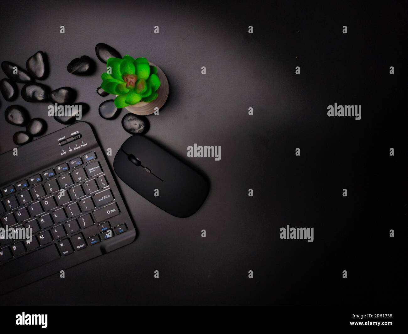 A modern laptop computer and mouse placed on a minimalist black table ...