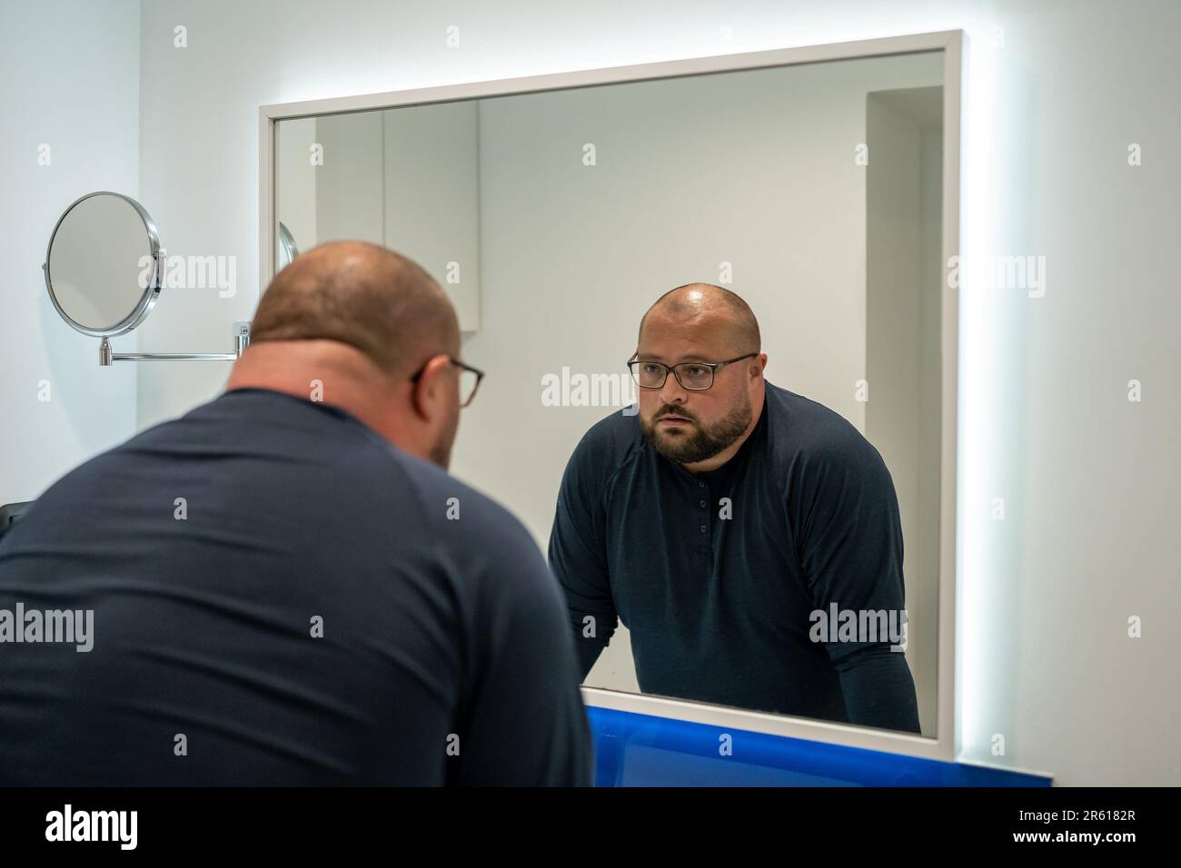 Sad fat lonely man looks in mirror in bath and thinks change life ...