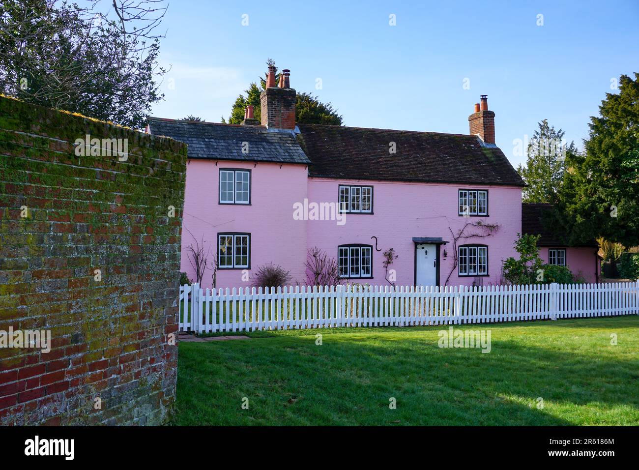 Pretty pink cottage house in rural village. Quaint house with white ...