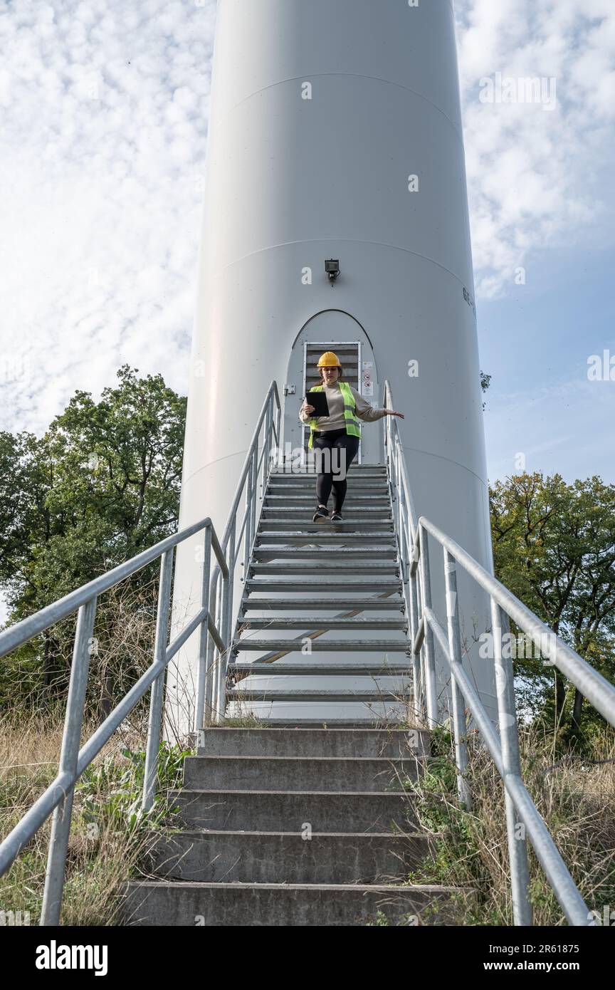 A female worker is making her way up down the stairs of a white windmill Stock Photo - Alamy