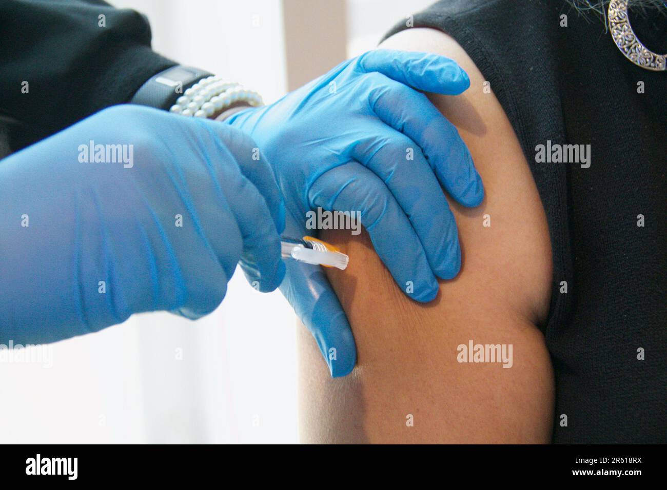 A doctor injecting with hypodermic needle on shoulder Stock Photo - Alamy