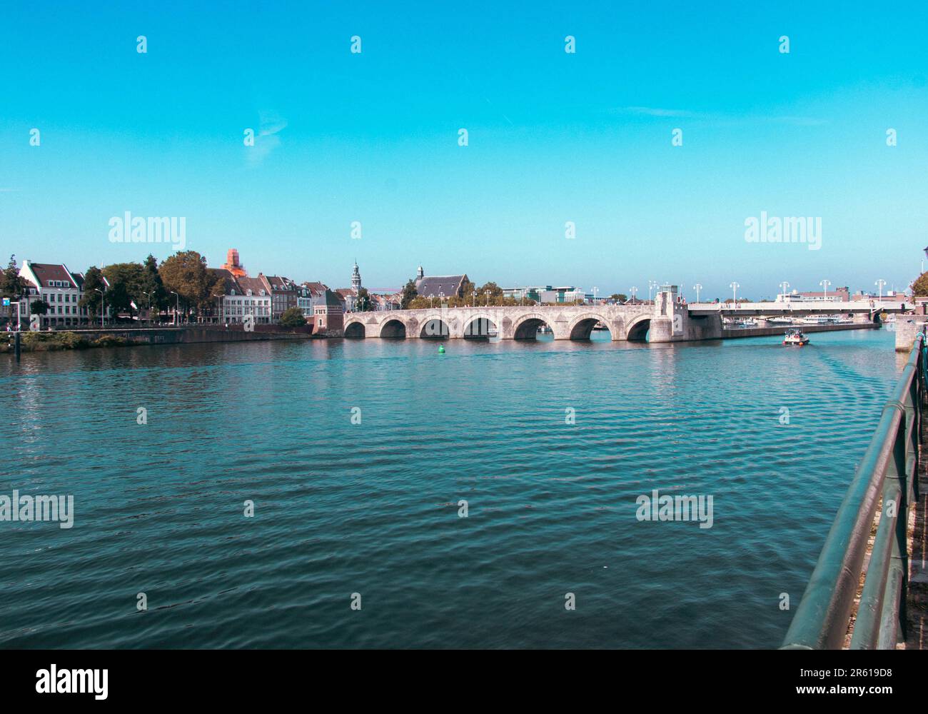 An arched bridge over the river with residential buildings lined on the ...