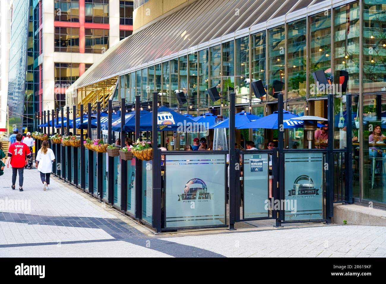 Toronto, Canada - May 13, 2023: A man and a woman walking down a paved ...