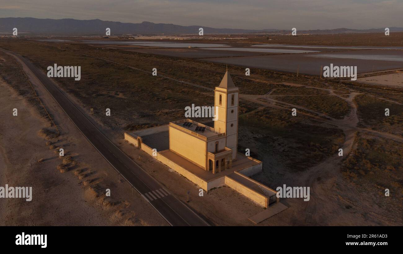 An aged church situated in a desert landscape with a slender spire ...