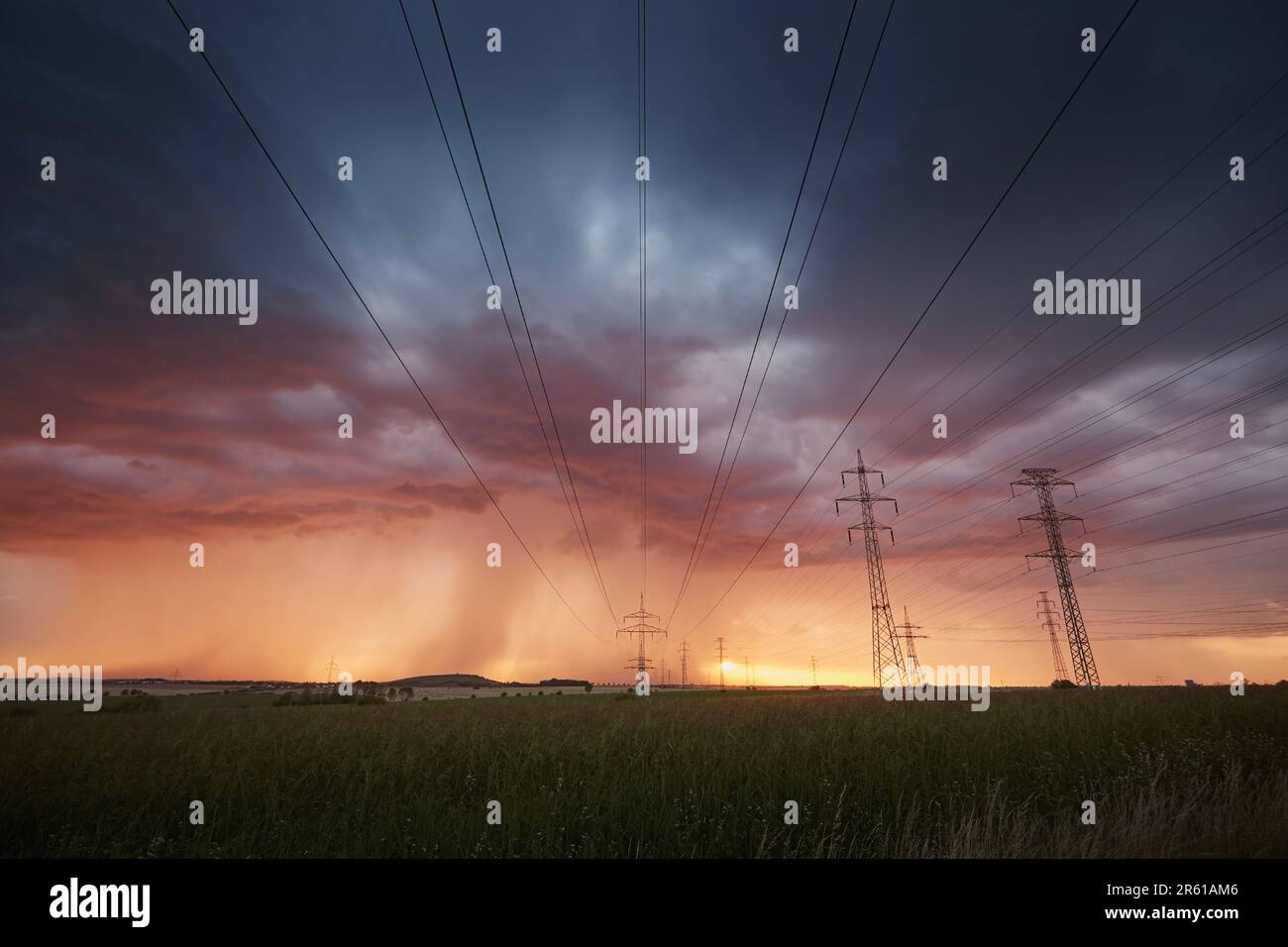 Landscape with electricity pylons under dramatic clouds of approaching ...