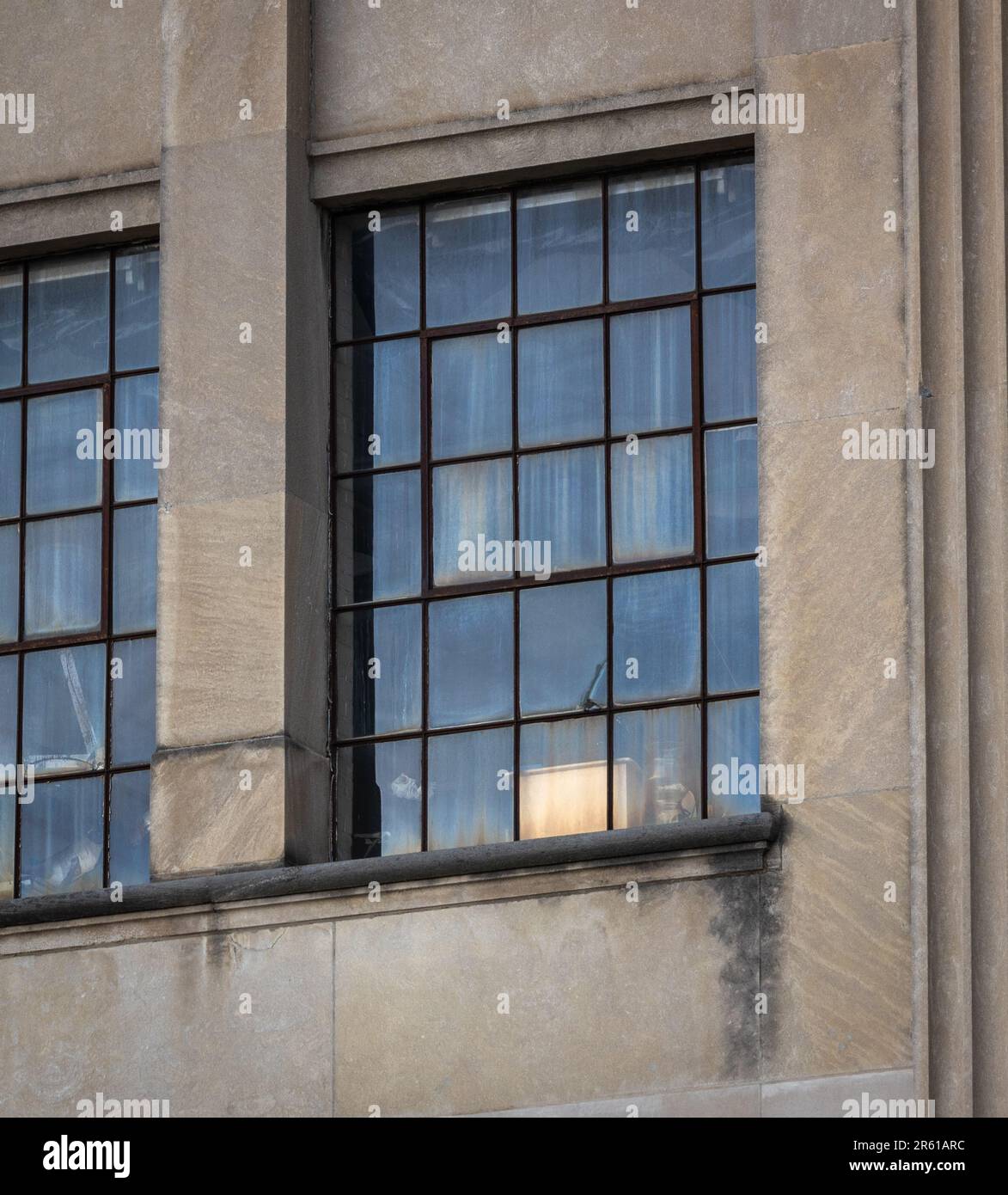 A gray stone building with old glass windows Stock Photo - Alamy