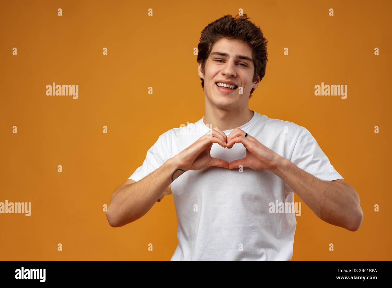 Portrait of happy handsome man making heart with fingers Stock Photo ...