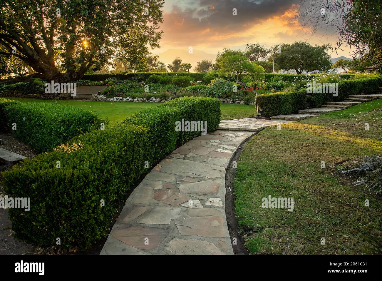 An idyllic pathway of stone paths winding through a vibrantly park on a ...