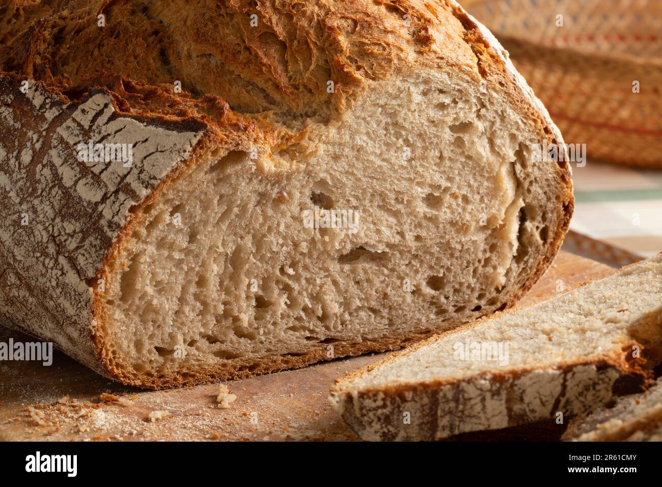 Fresh loaf and slices of sourdough farmers bread close up on a cutting ...