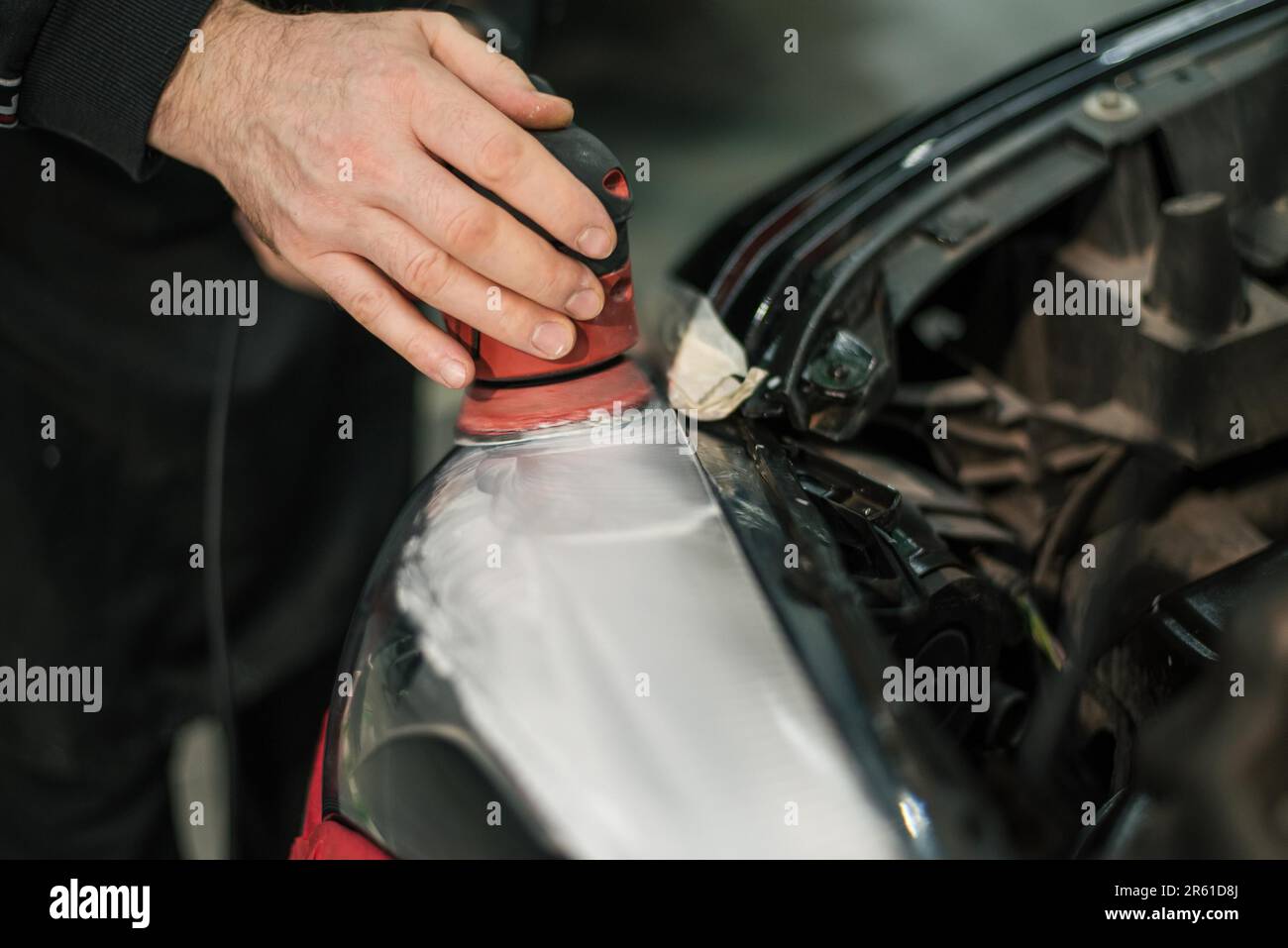 A person is professionally detailing a vehicle's trunk compartment ...