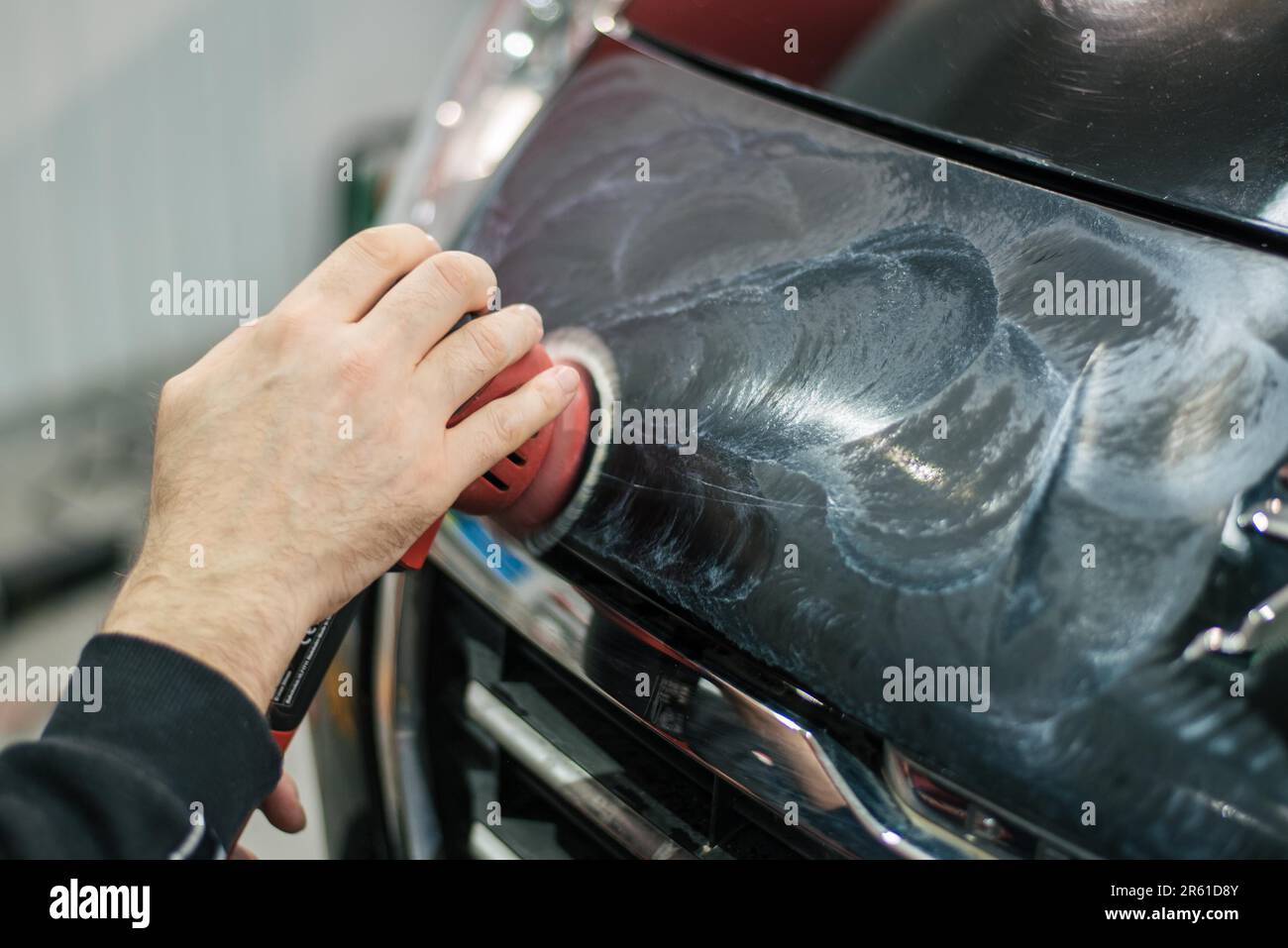 A person is professionally detailing a vehicle's trunk compartment ...