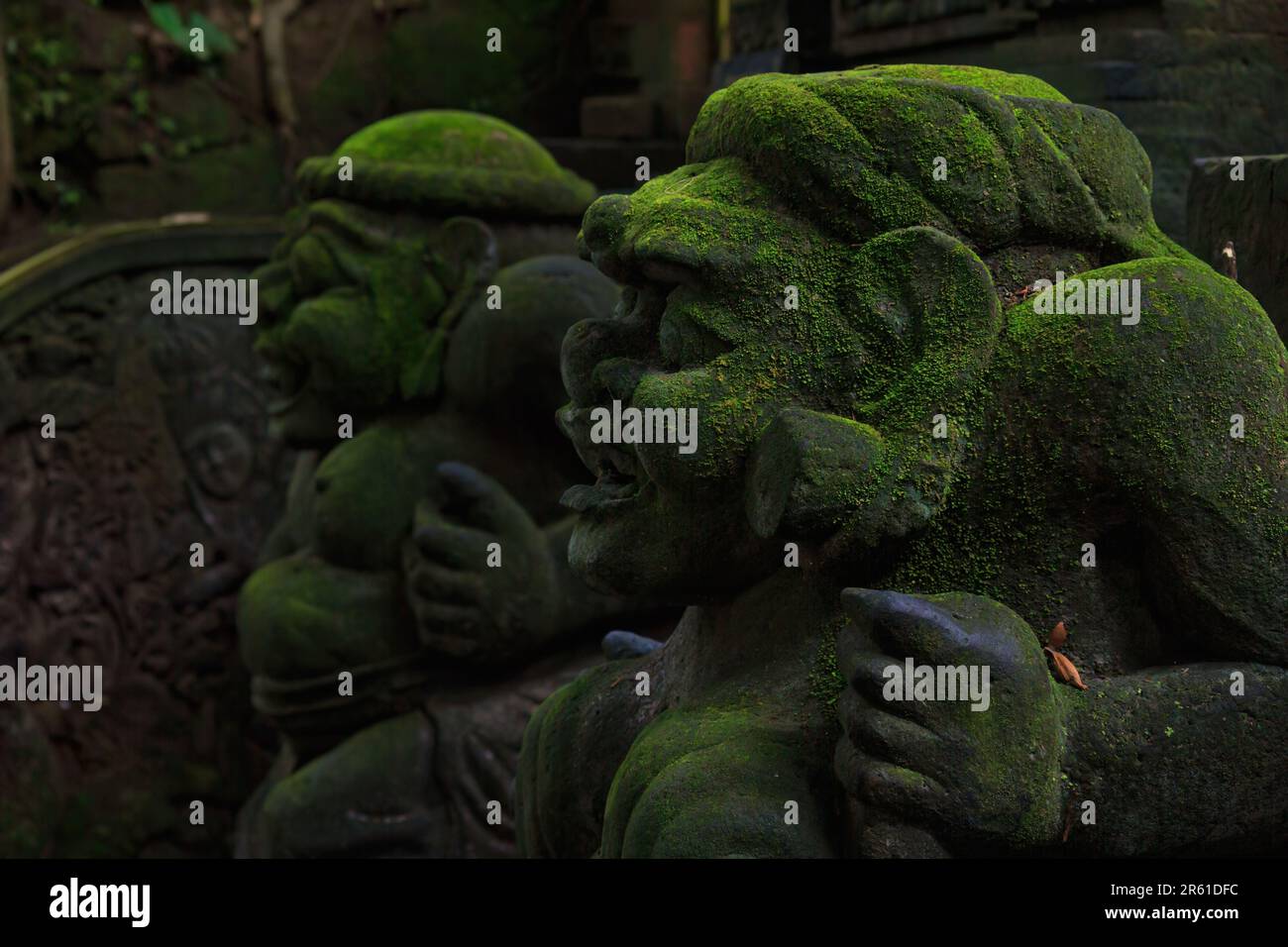 The moss-covered statues in the Monkey Forest jungle stand as guardians ...