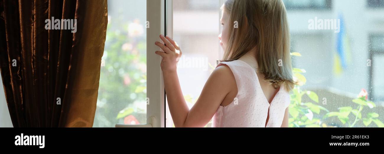 Little girl in pink dress standing on windowsill at open window Stock ...