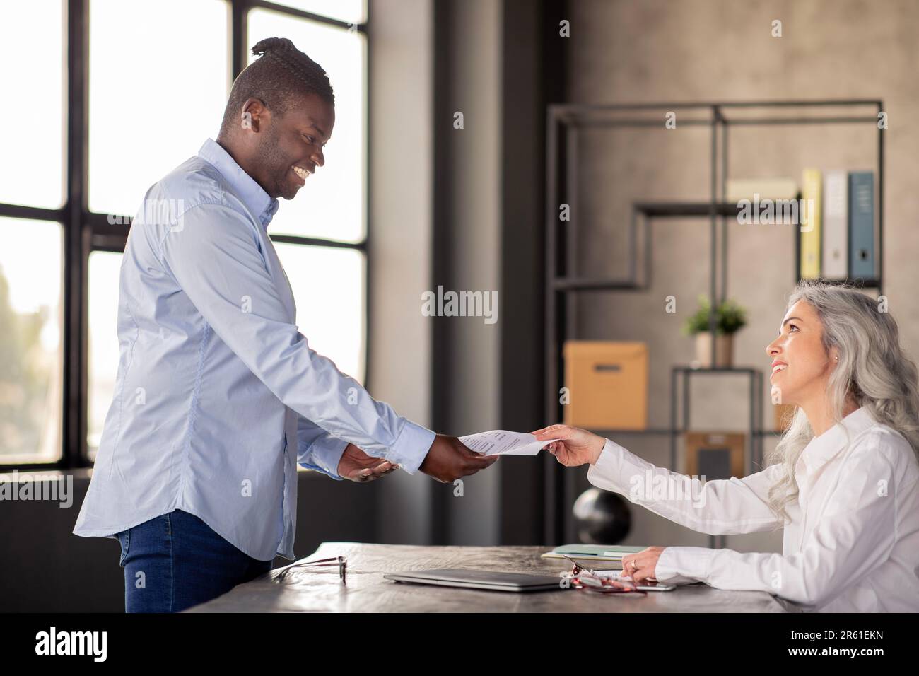 African Man Giving Resume To HR Manager Woman In Office Stock Photo - Alamy